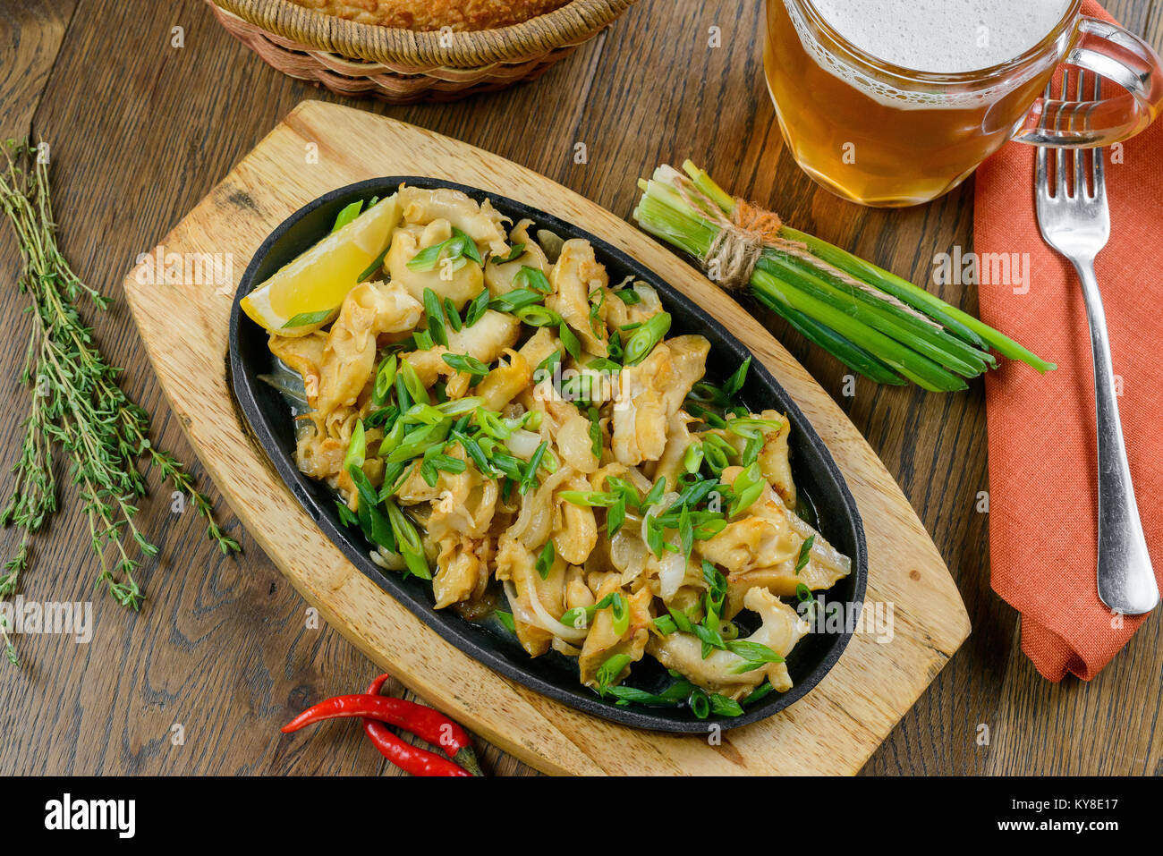 Fried clamps with greens on oval fry pan garnished with herbs Stock ...