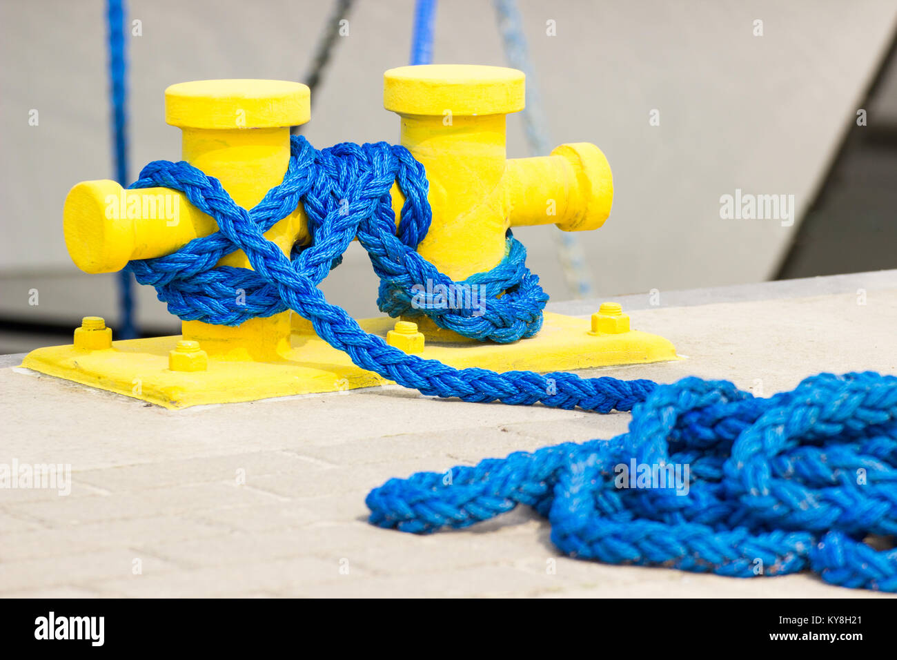 Rope and yellow mooring bollard in seaport hi-res stock photography and ...