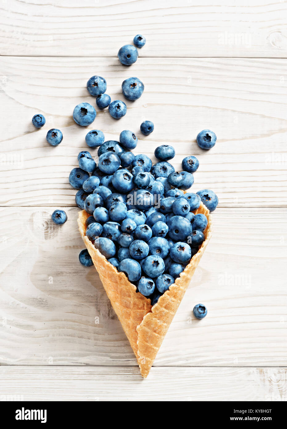 Blueberry explosion. Photo of blueberry in waffle cone on white wooden ...