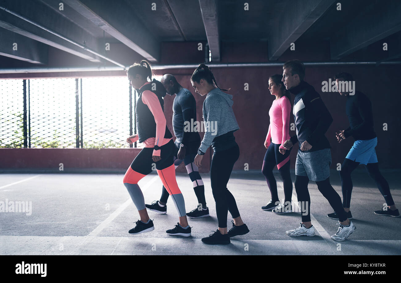 Group of healthy active multiracial friends urban running in a ...