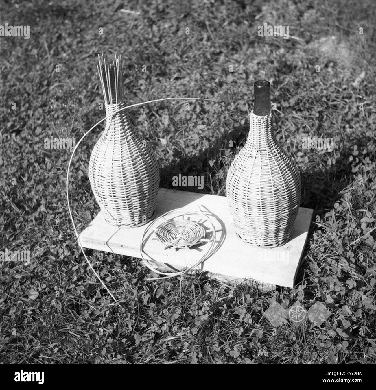 Pletenje oboda steklenic, dno posebej, vse iz srobota. Peč 1949 Stock ...