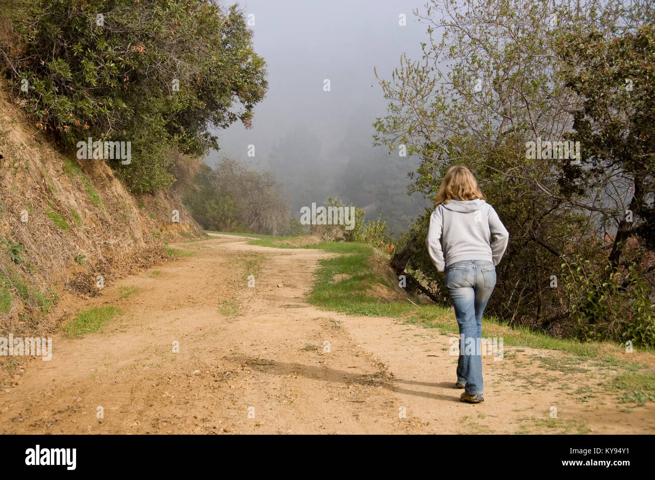 Lone woman hiking on mountain trail Stock Photo - Alamy