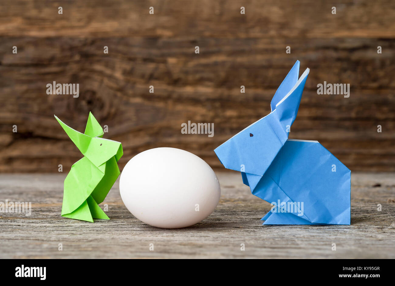 Two colorful origami Easter bunny rabbits made of paper in green and ...