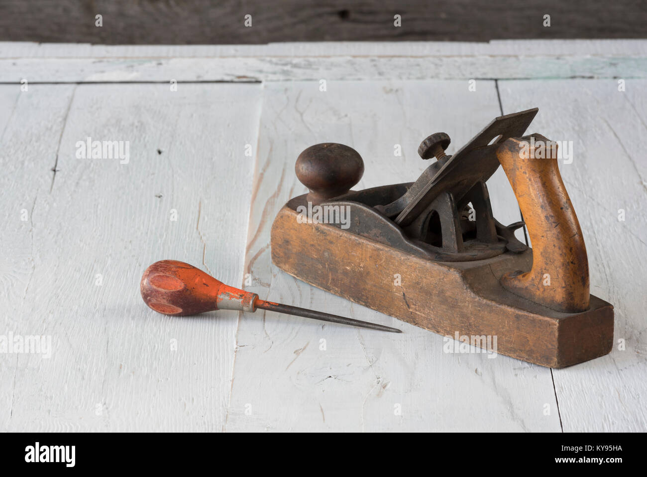 close-up of antique, vintage wooden block plane and awl with orange ...