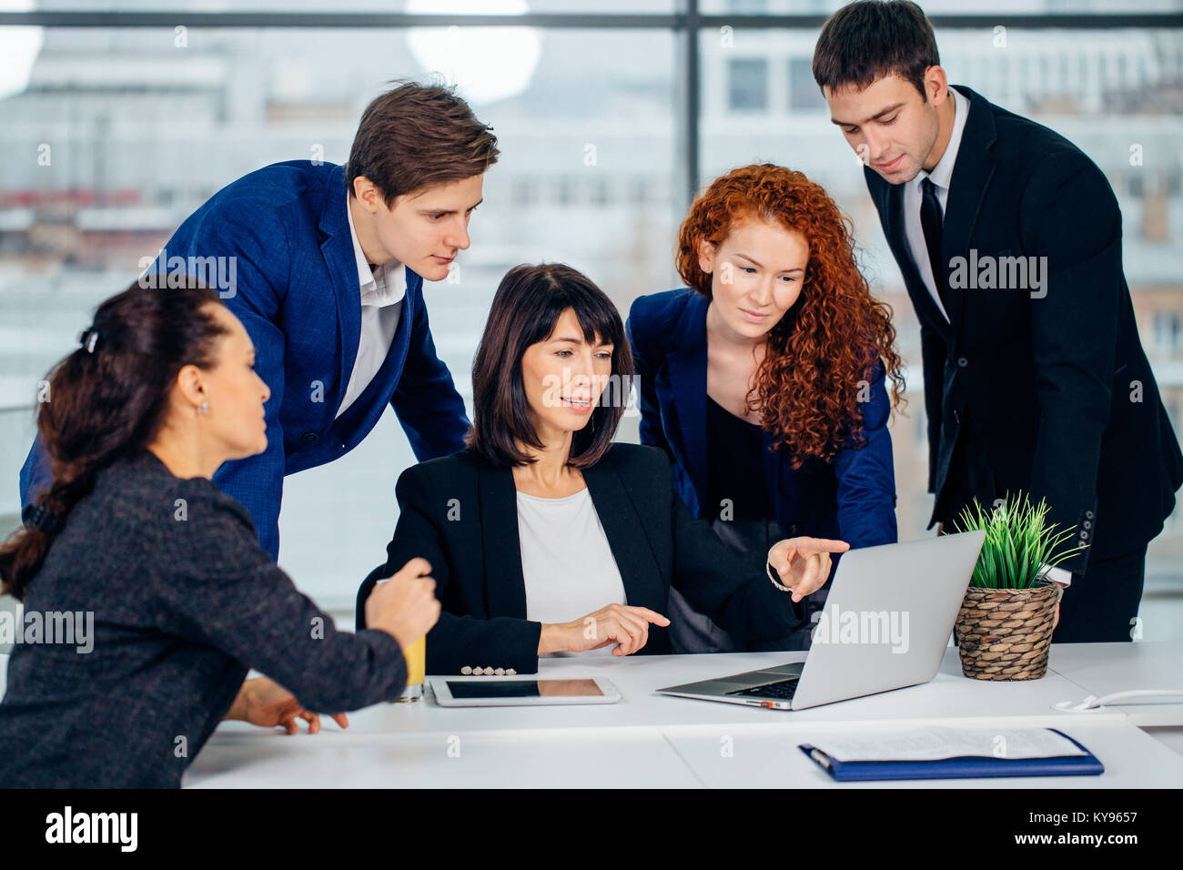 male and female business people around laptop computer in office Stock ...