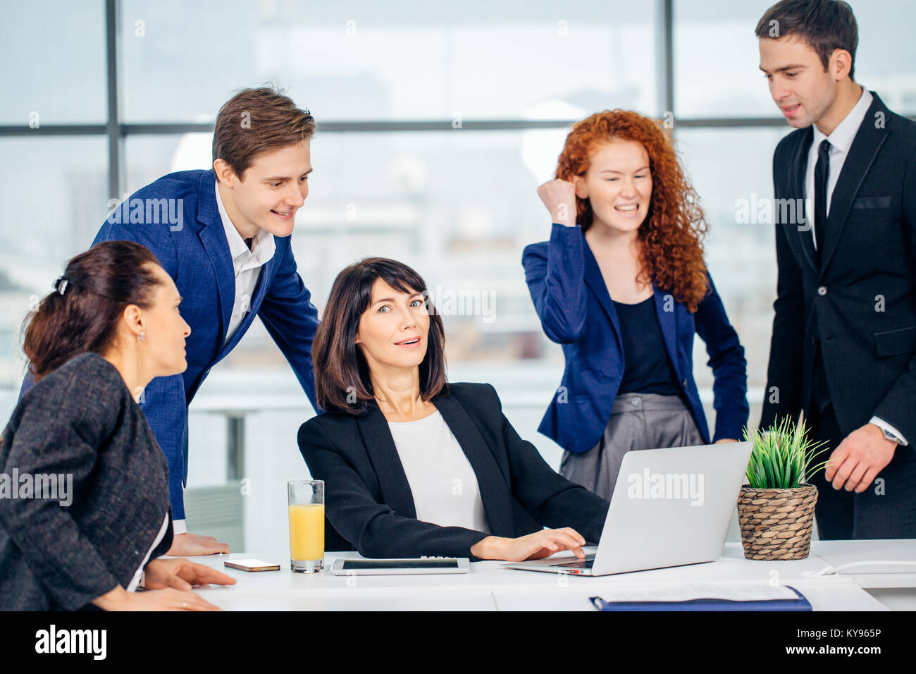 male and female business people around laptop computer in office Stock ...