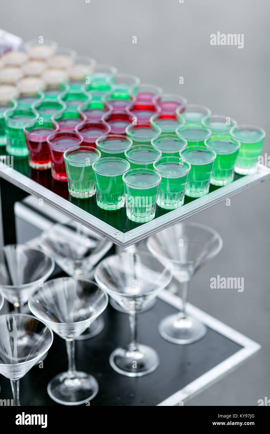 row line of different colored alcoholic cocktails on a party. wedding ...