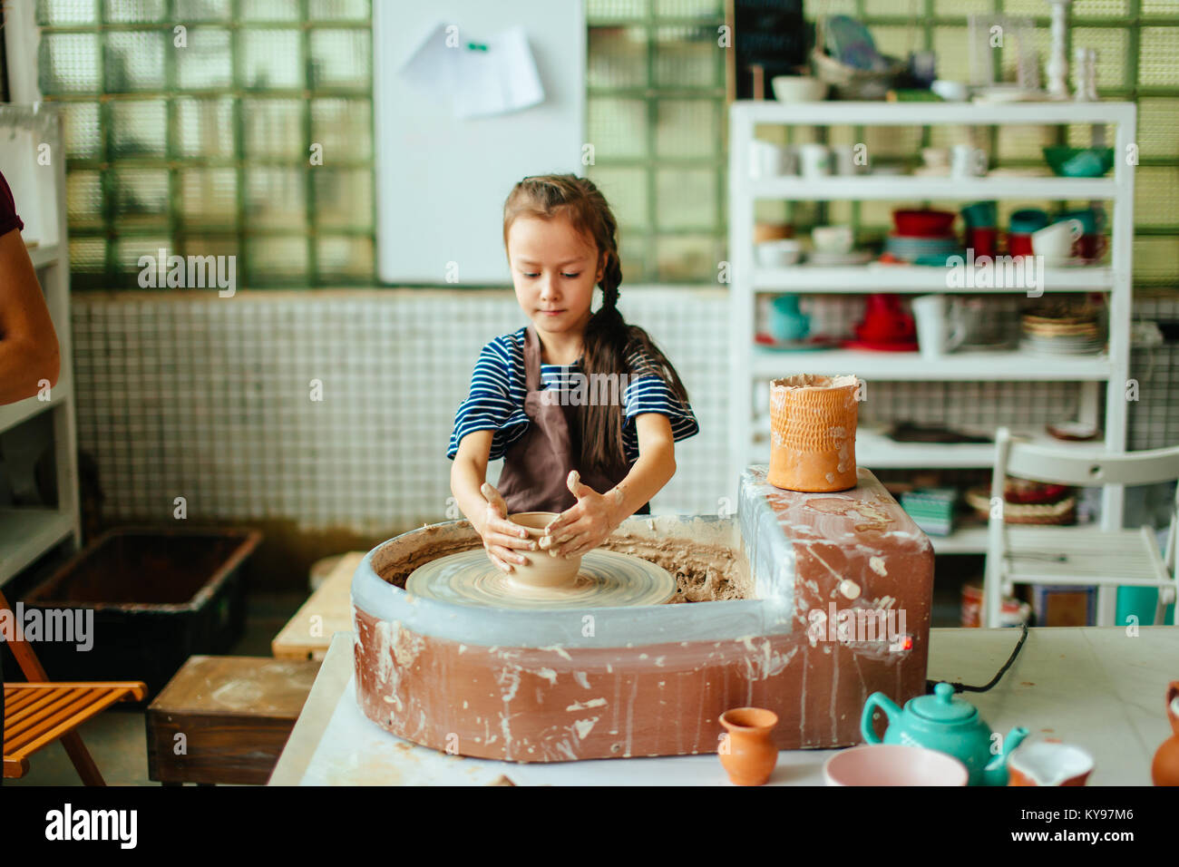 Child sculpts from clay pot. modeling on potter wheel Stock Photo - Alamy