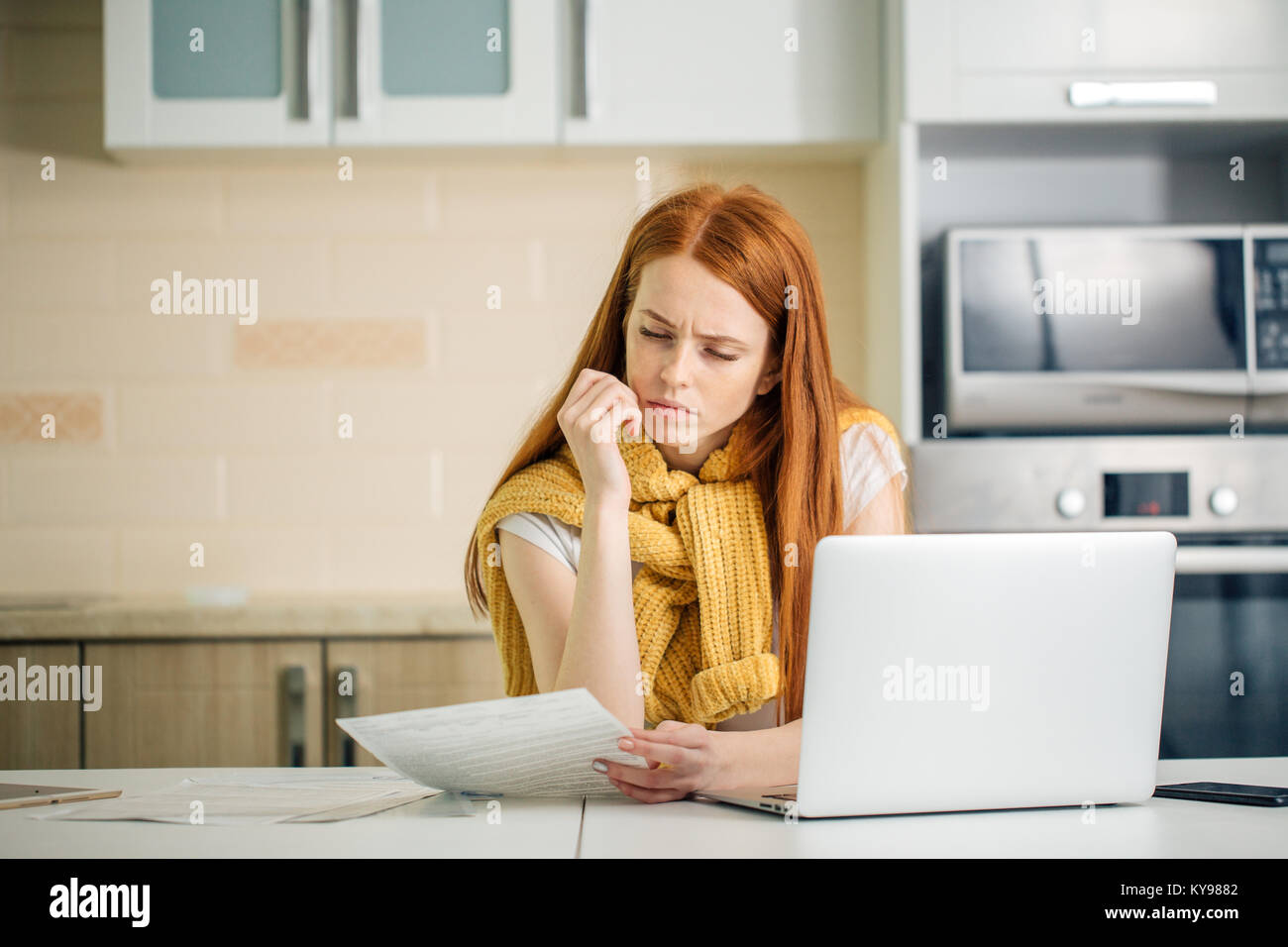woman looking at screen of laptop with serious and concentrated ...
