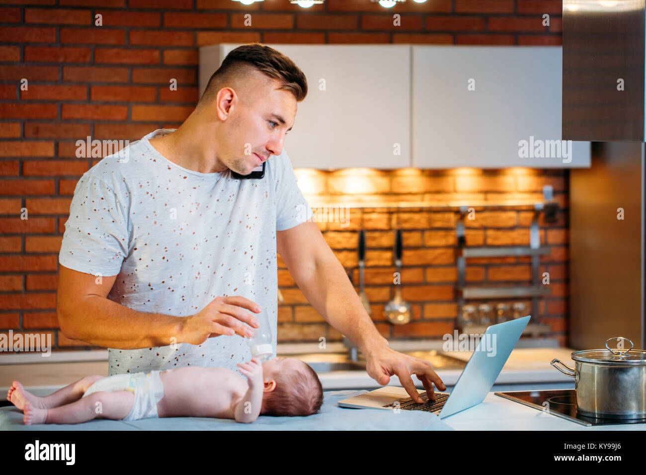 Man working from home and taking care of baby Stock Photo - Alamy
