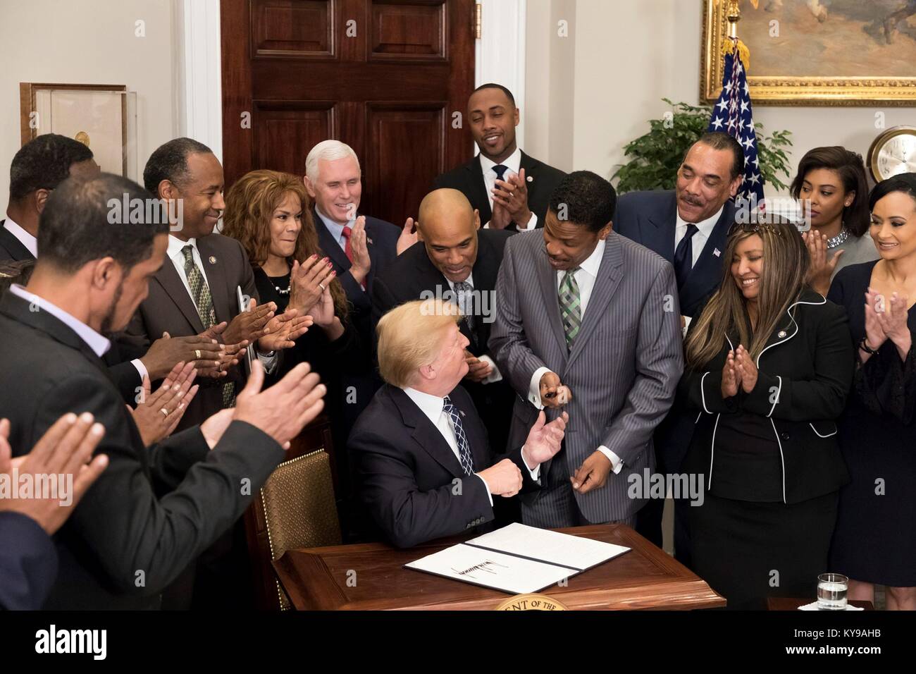 U.S. President Donald Trump hands the pen used to sign a proclamation ...