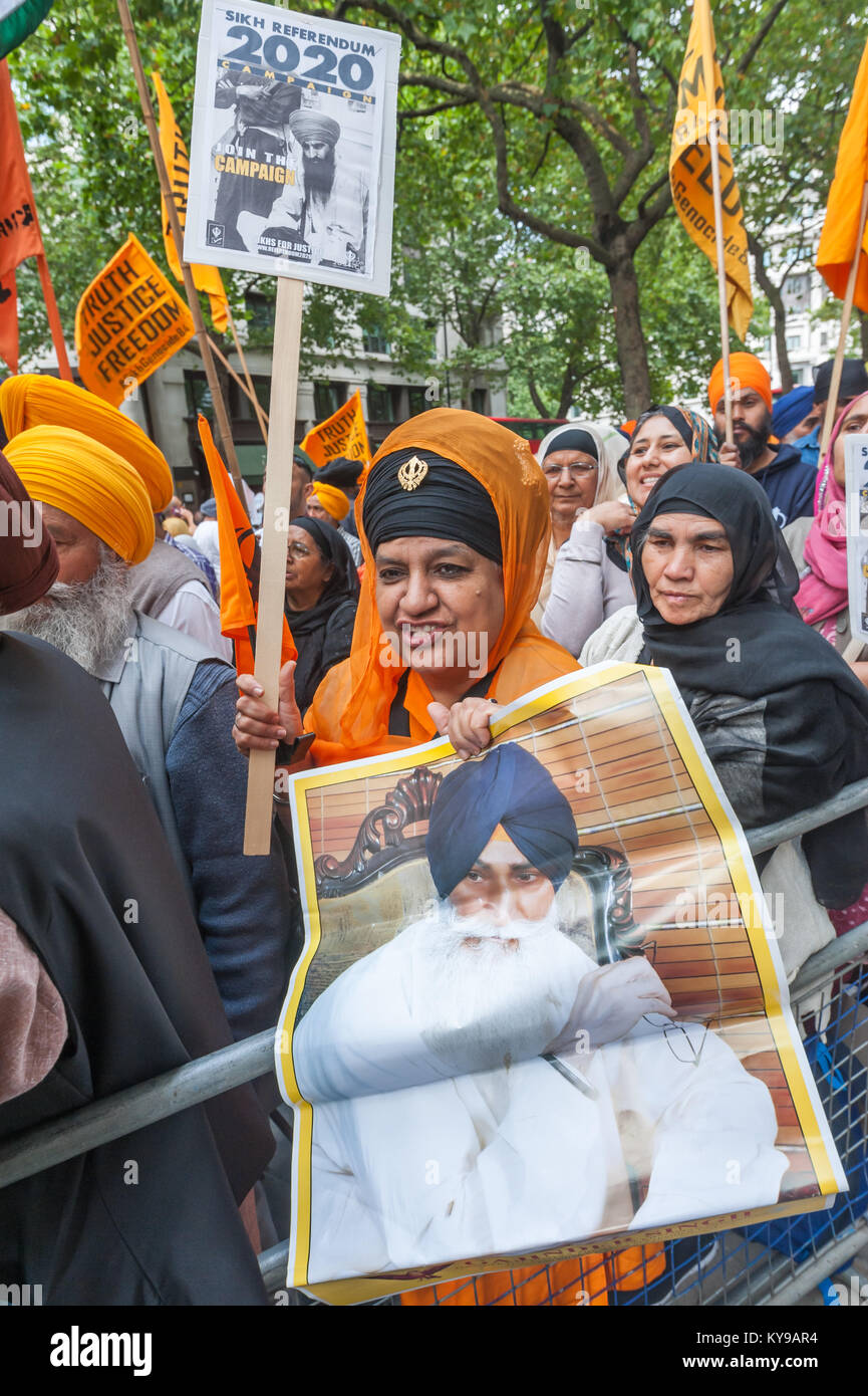 A Sikh woman holds a poster of Gajinder Singh, one of the founders of ...