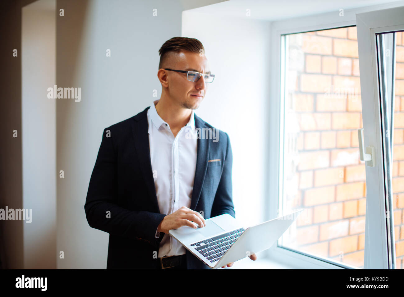 handsome man wearing glasses working with laptop in office Stock Photo ...