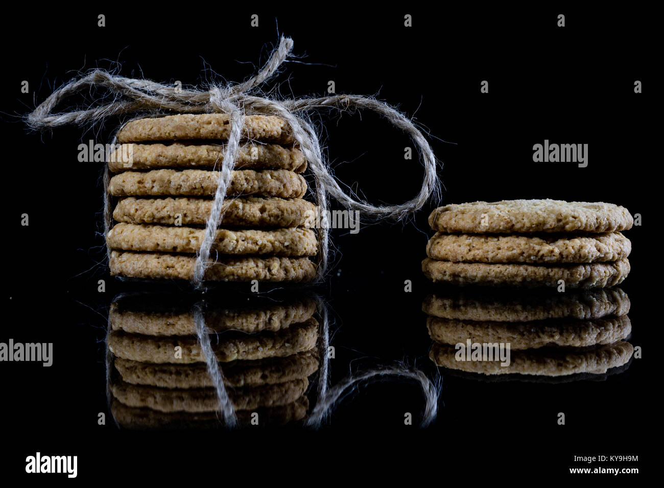 Crumbly biscuits tied with a string on a glass table. Tasty cakes on a ...