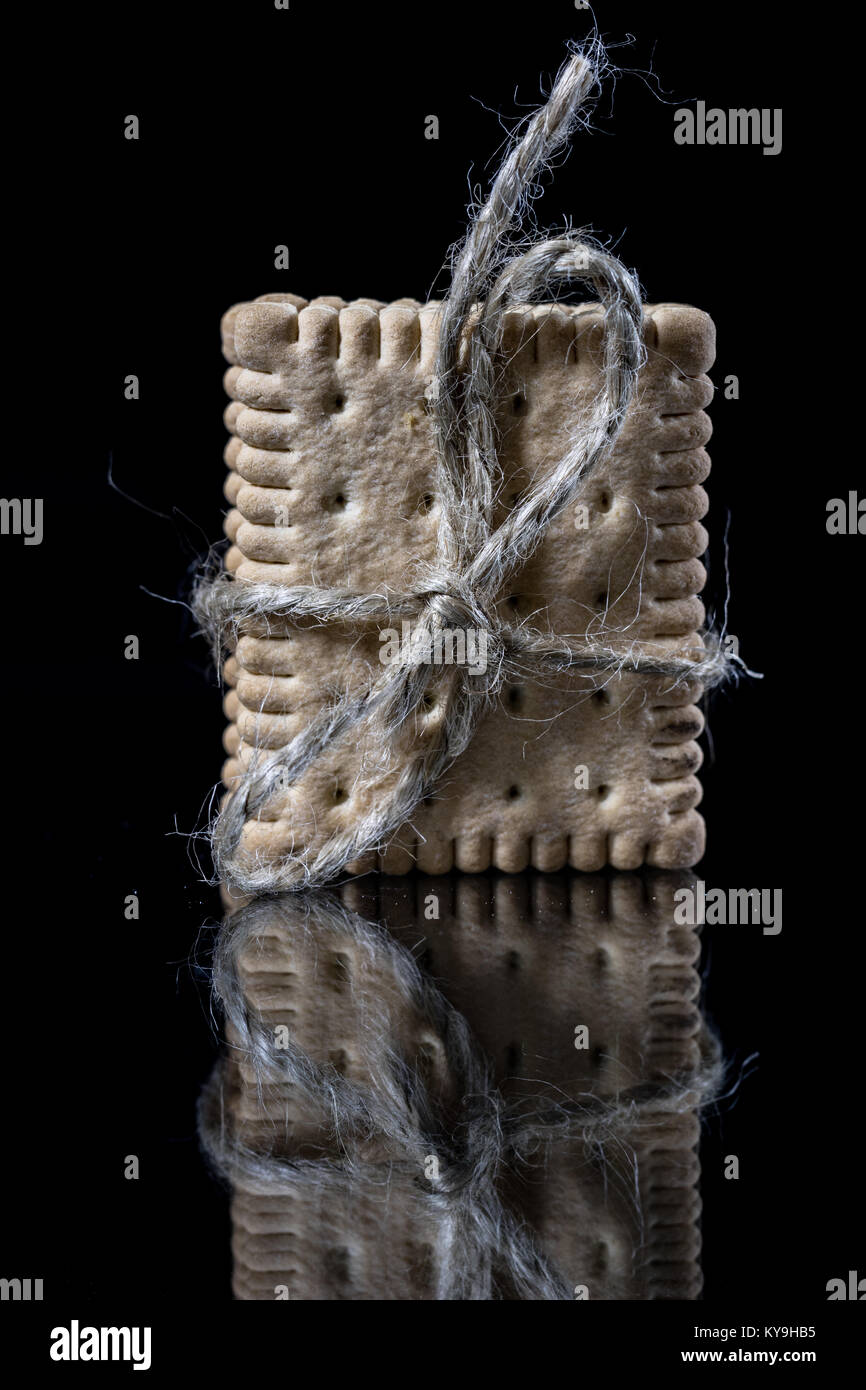 Crumbly biscuits tied with a string on a glass table. Tasty cakes on a ...