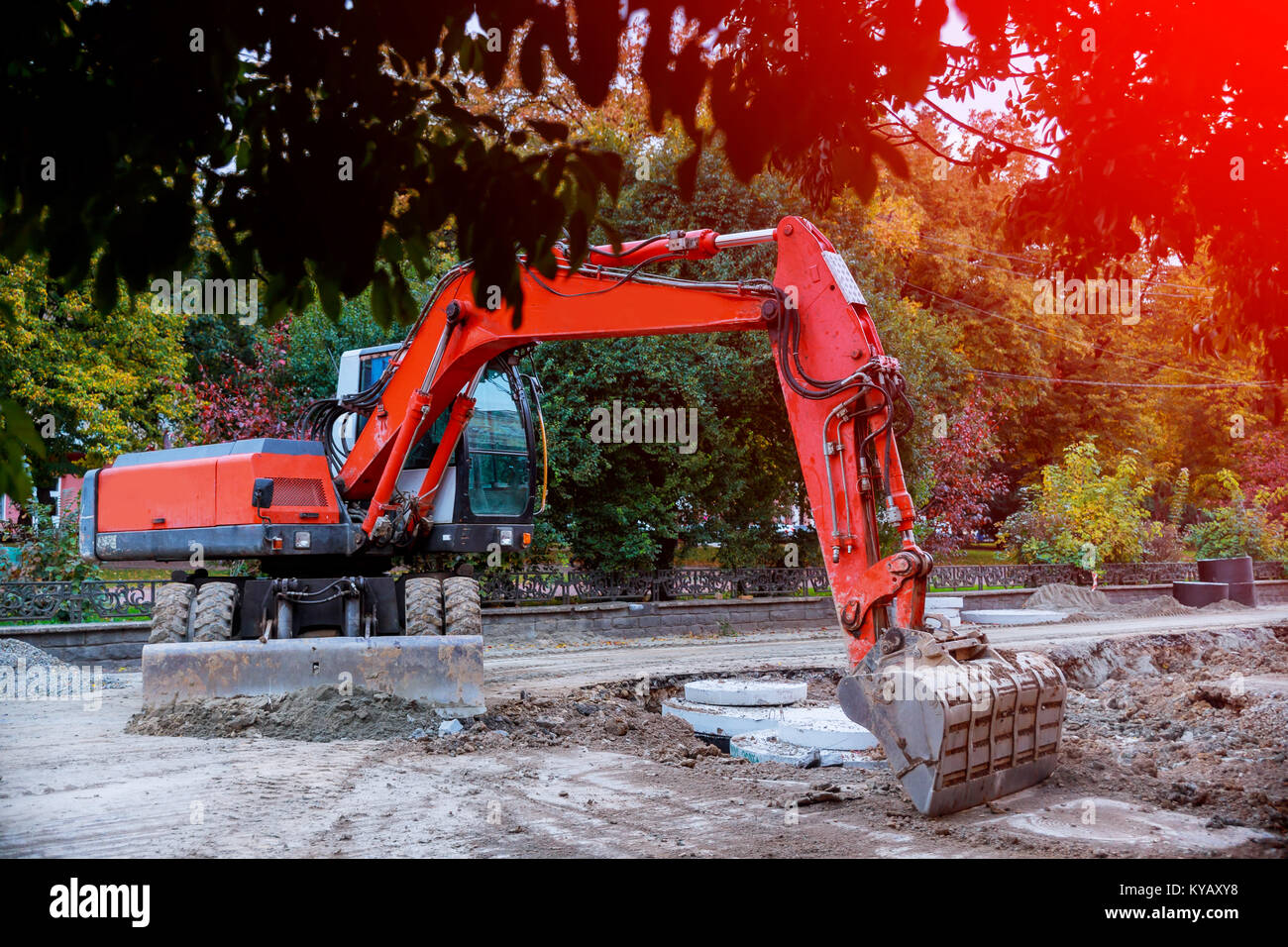 excavator digging a hole, breaking street asphalt, repairing damaged ...