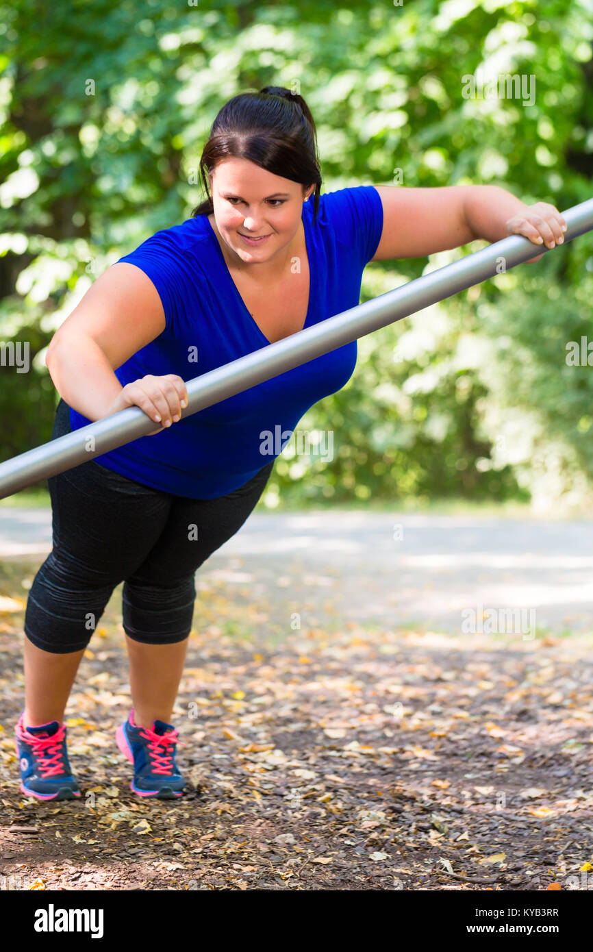 Obese woman doing sport stretching outdoors in park Stock Photo - Alamy