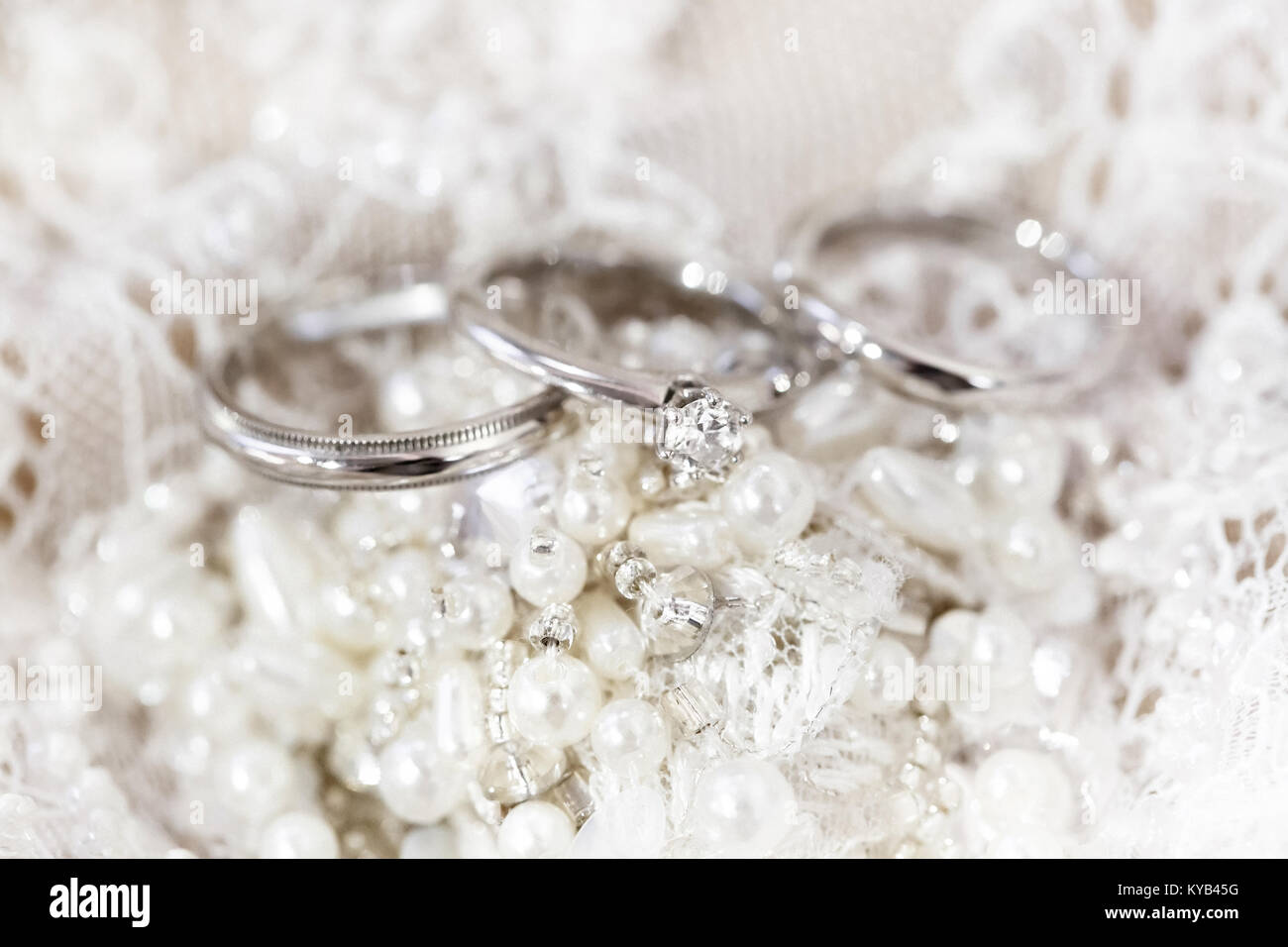 Wedding rings with a diamond on wedding dress background Stock Photo ...