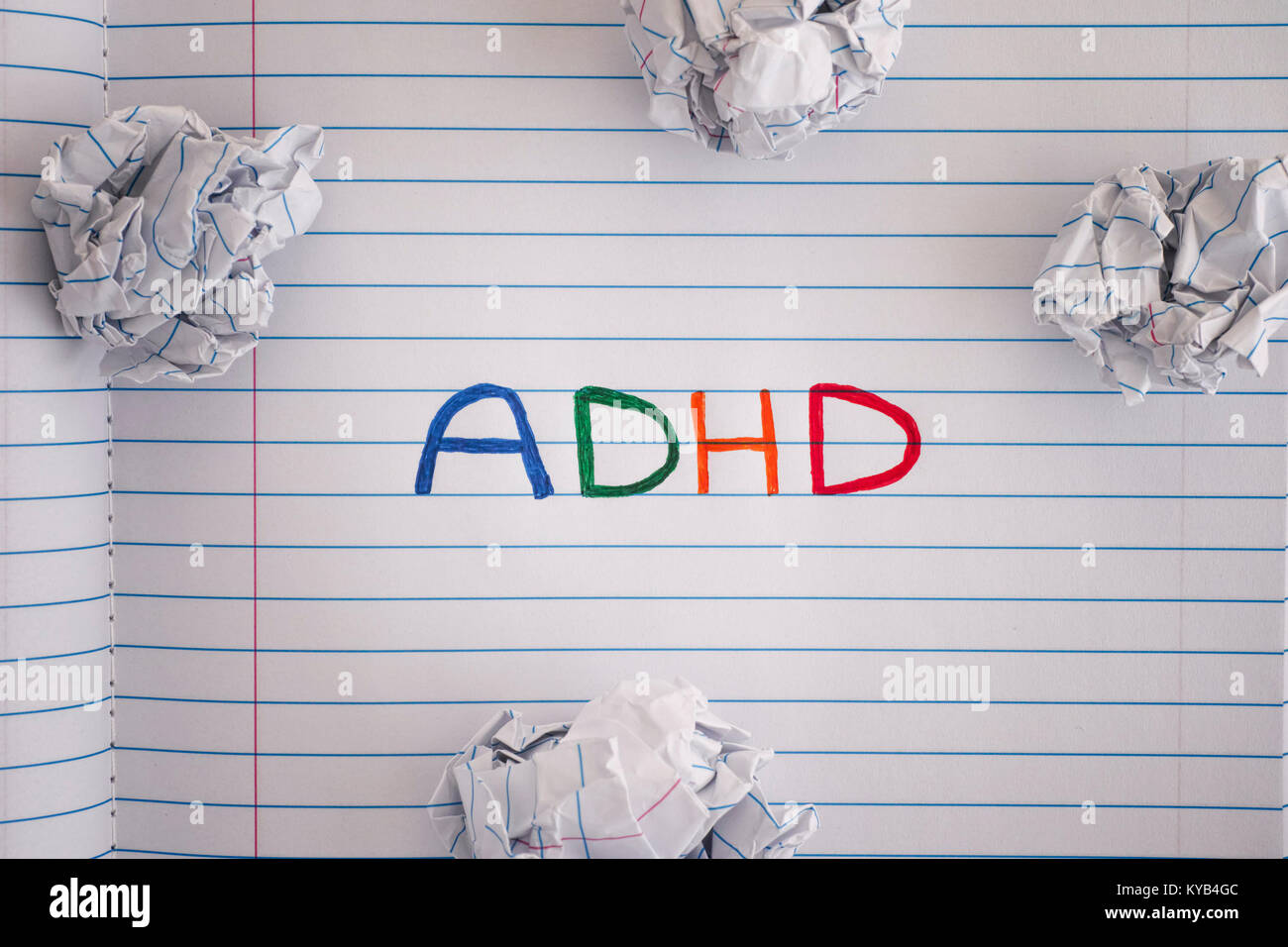 ADHD. Abbreviation ADHD on notebook sheet with some crumpled paper ...