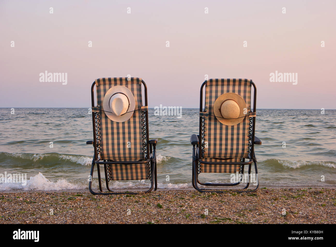 Rear view beach chairs on seashore Stock Photo - Alamy