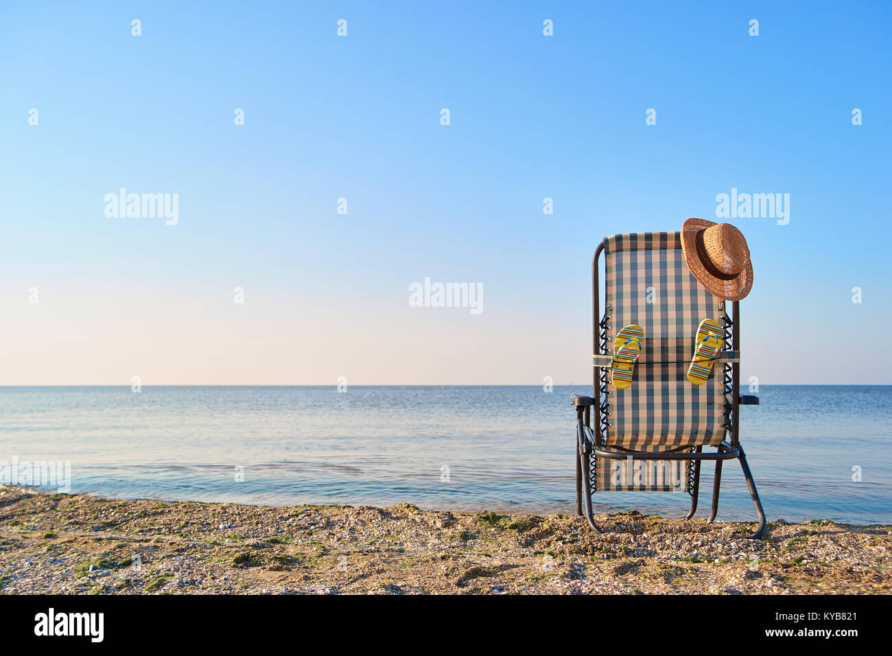 Back view woman's hat on deck chair and attached flip flops Stock Photo ...