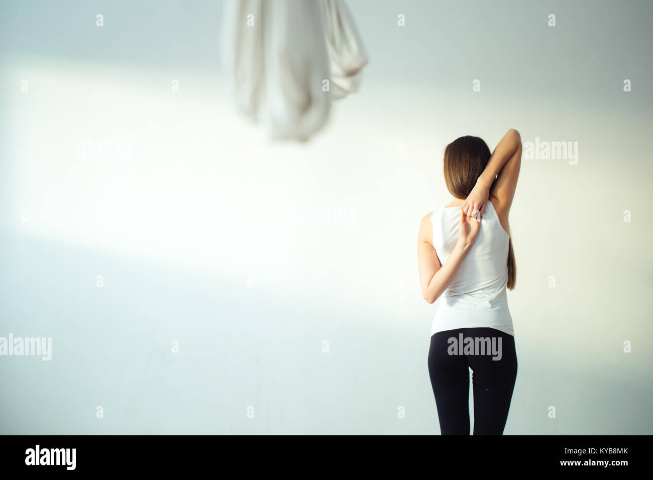 Rear view of fit woman doing gomukhasana in yoga class Stock Photo - Alamy