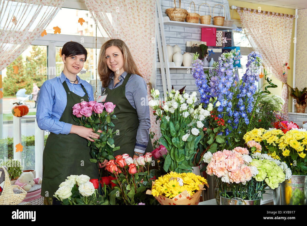 Women flower sellers. Two attractive young women working in flower shop ...