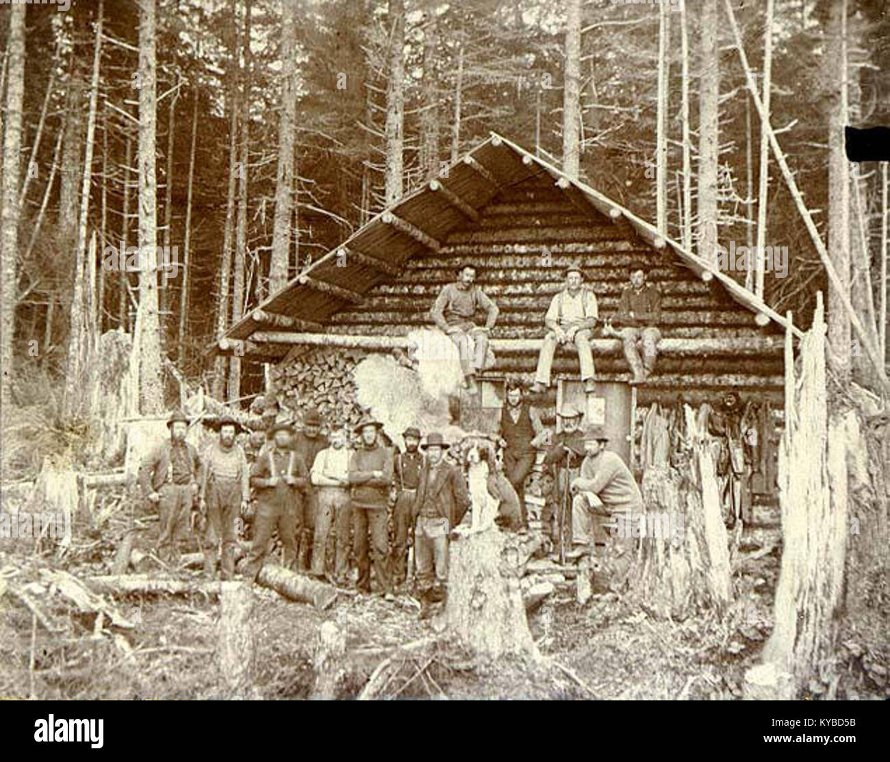 This historical photograph shows men outside a log cabin at the mining ...