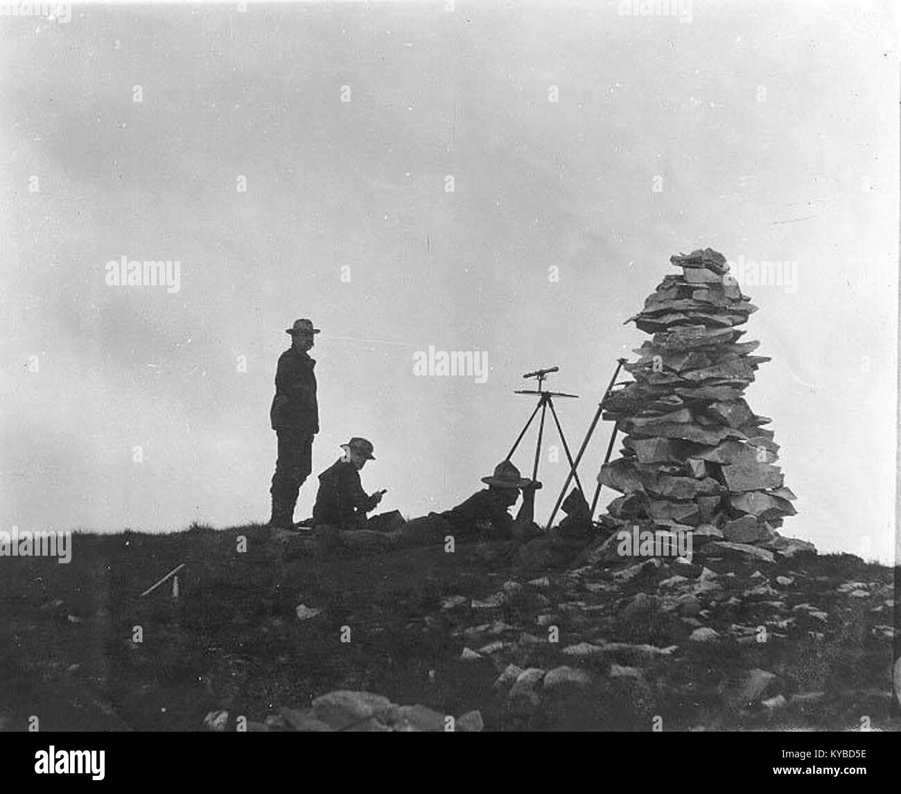 A photograph from around 1910 showing men setting up surveying ...