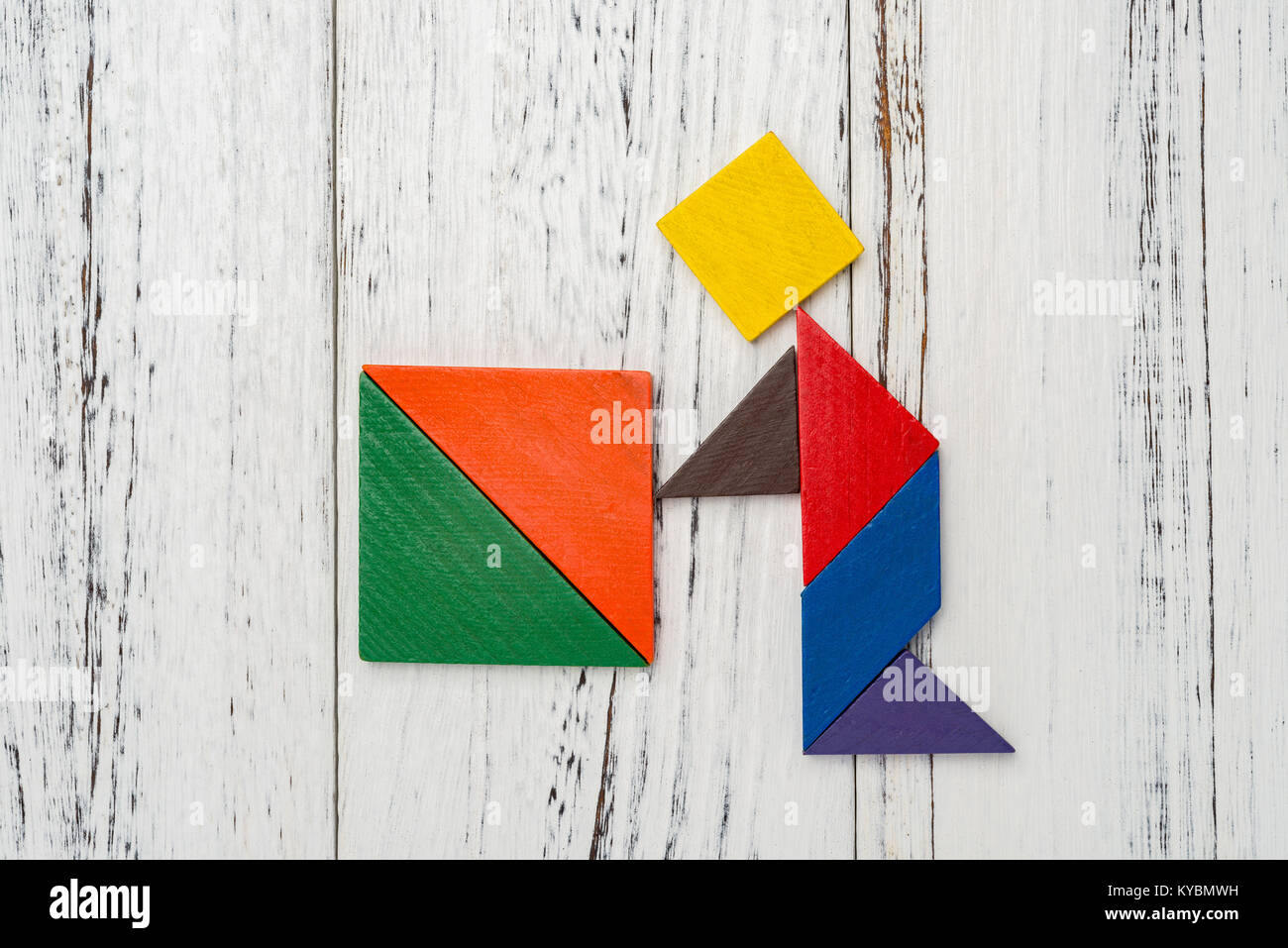 wooden tangram shape like a people with a box nearby Stock Photo - Alamy