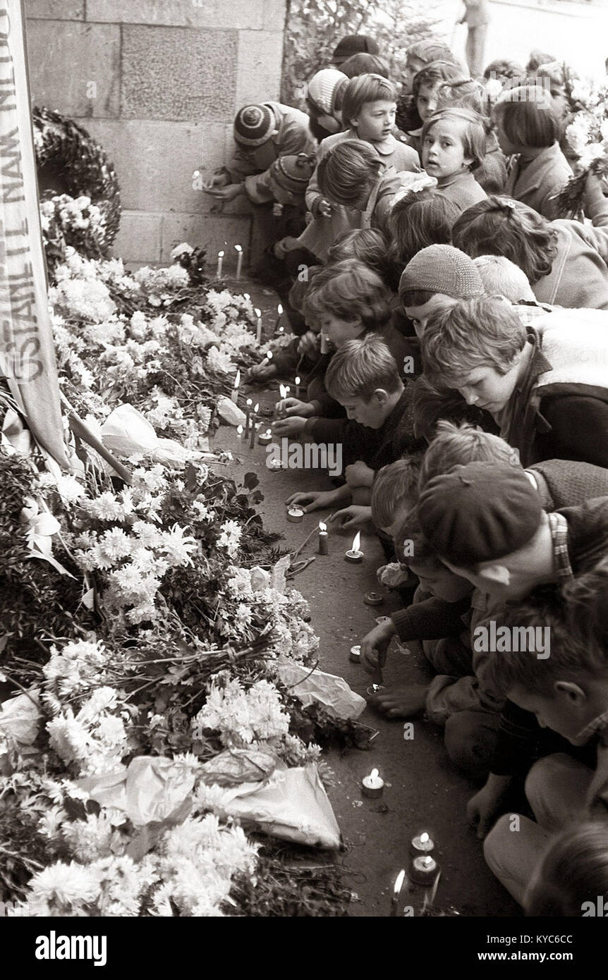Children light candles on the graves of victims before the Day of the ...