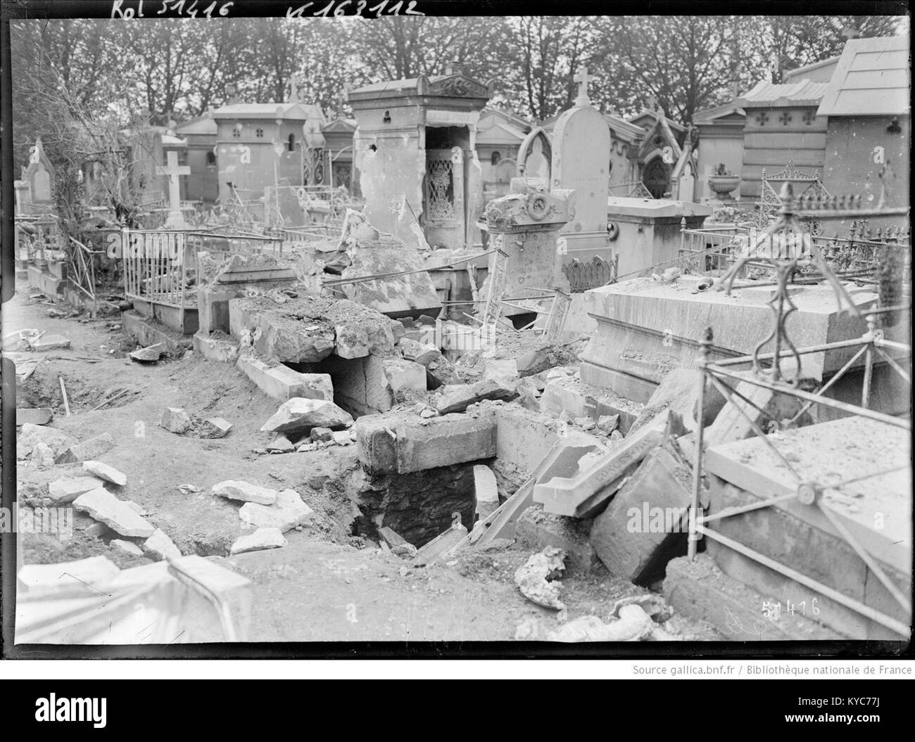 The photograph documents wartime bomb damage in Père Lachaise Cemetery ...