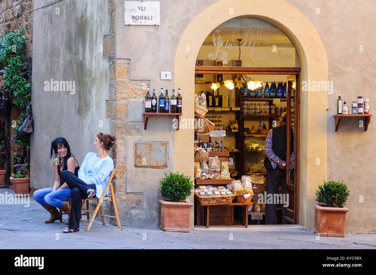Ladies have a break and a chat in front of the food shop Stock Photo ...