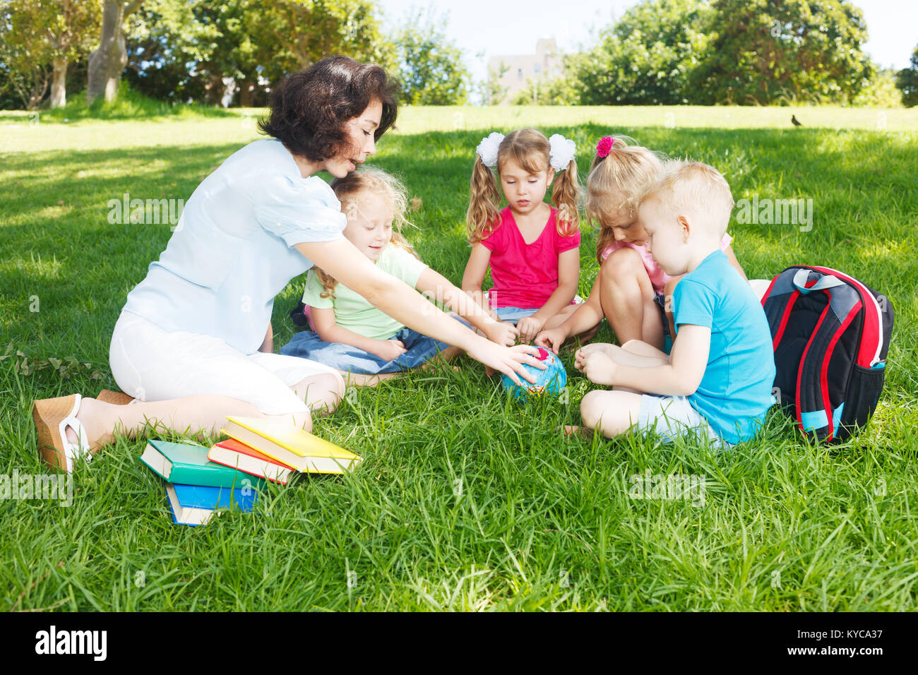 Pre-school children showing unity with teacher Stock Photo - Alamy