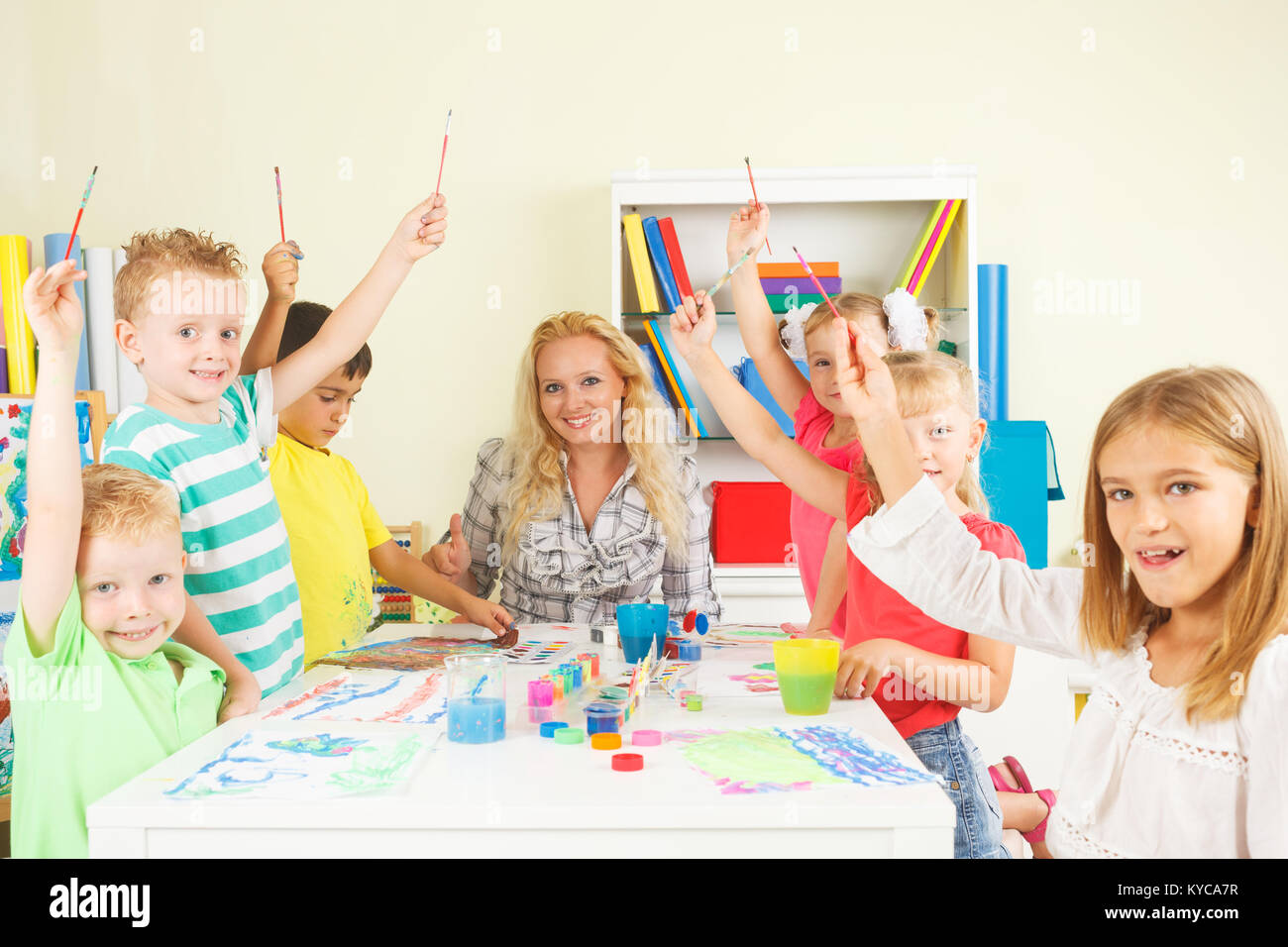 Pre-school children showing unity with teacher Stock Photo - Alamy