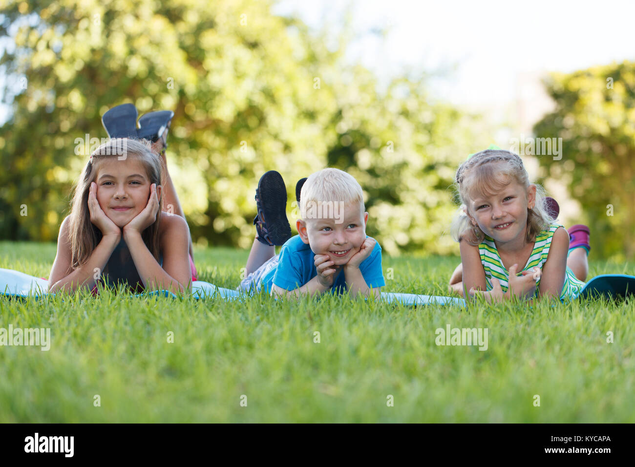 Happy children lying in grass Stock Photo - Alamy