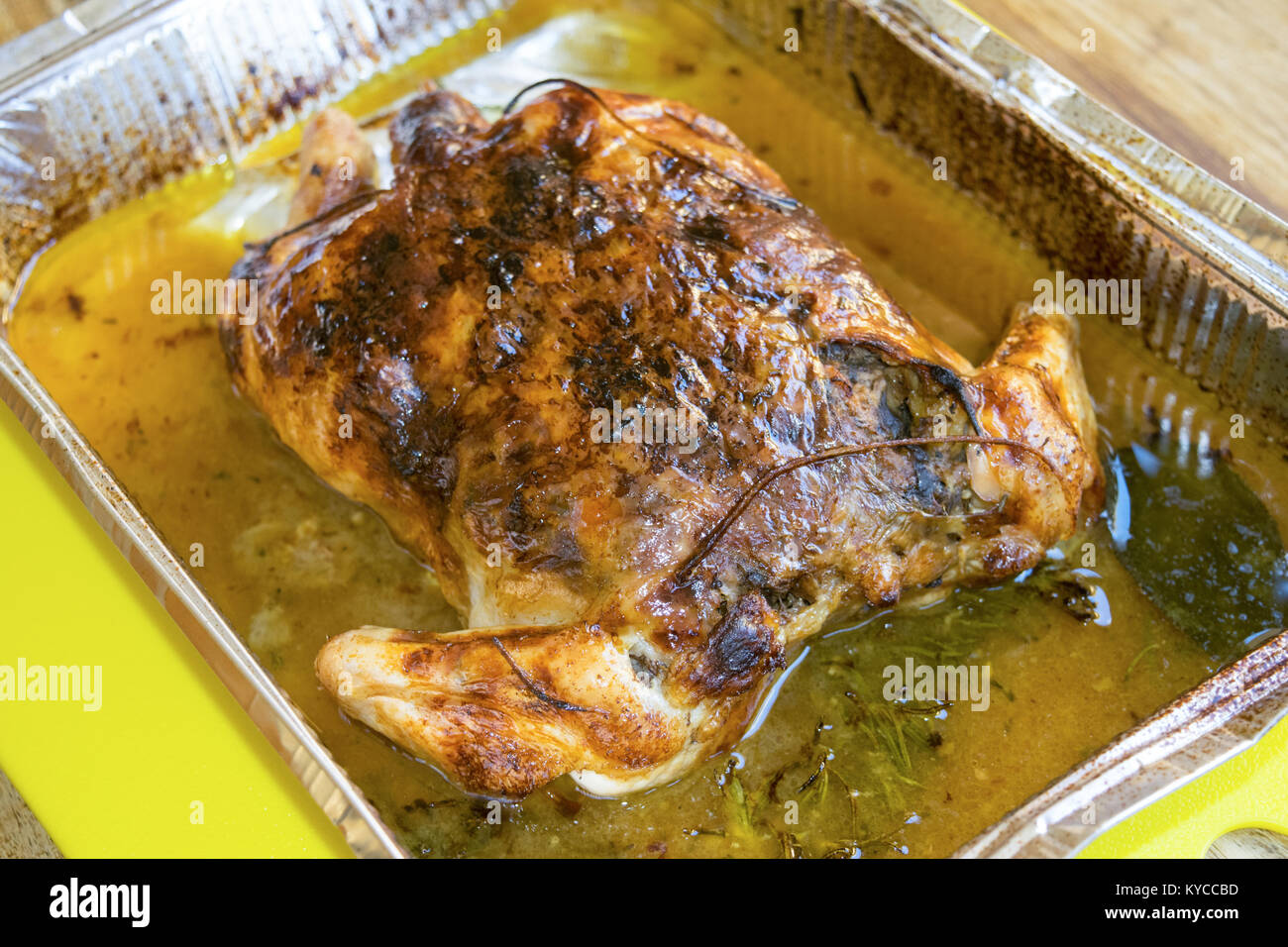 spit roasted chicken with its fats in a metallic container Stock Photo ...