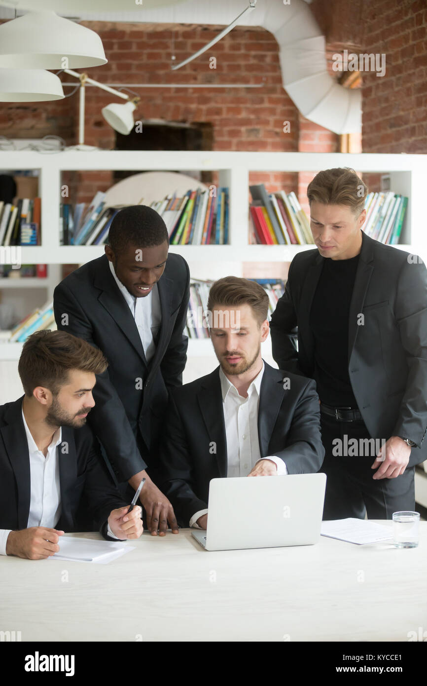 African and caucasian businessmen in suits talk share ideas with laptop ...