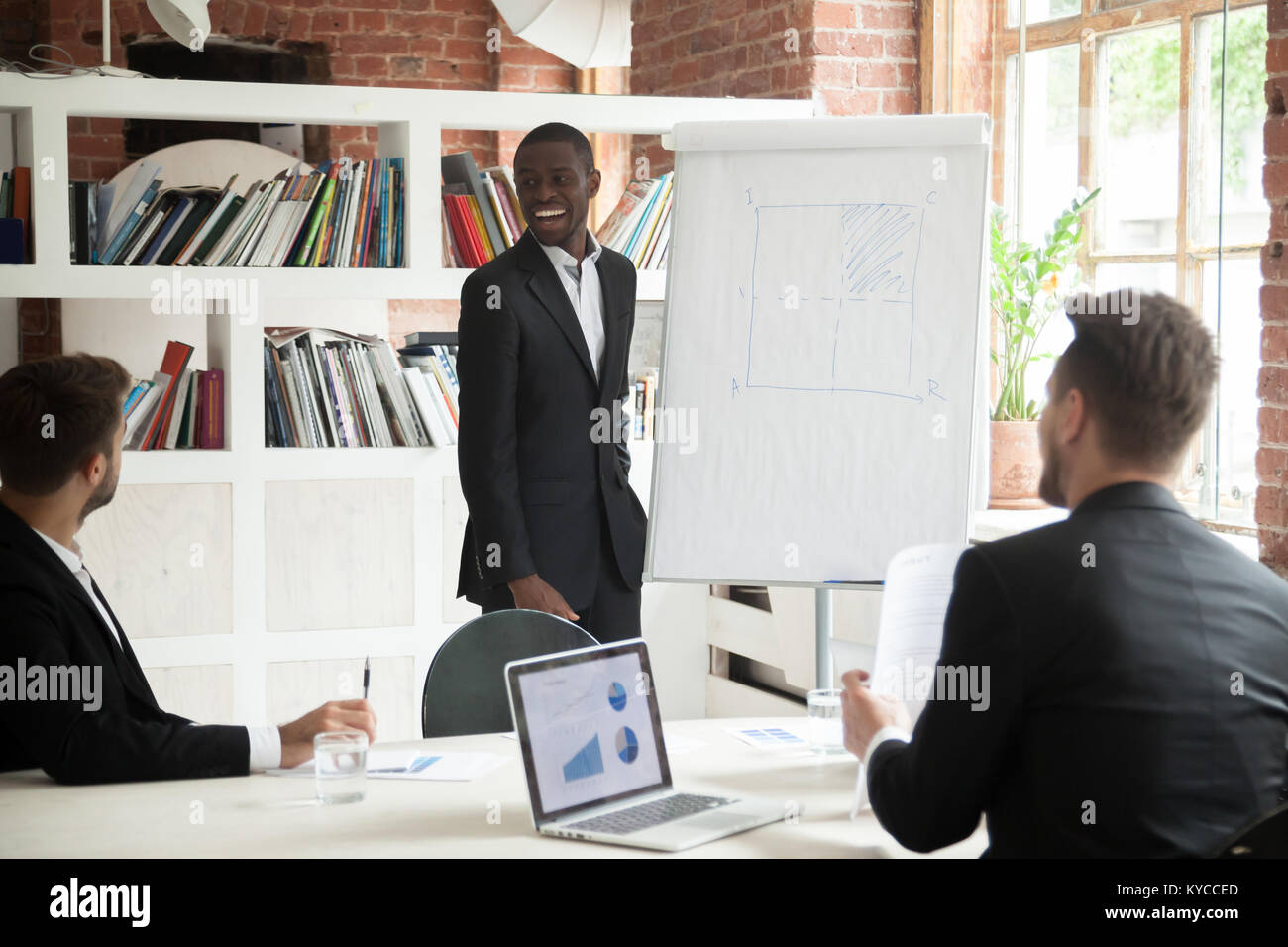 Smiling friendly african american coach giving presentation to ...