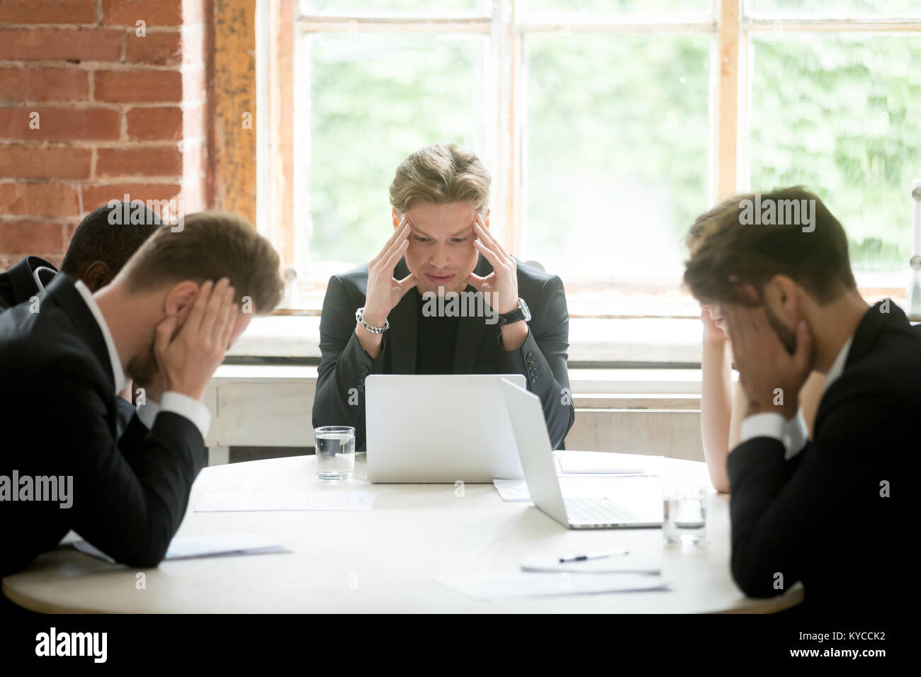 Stressed boss and executive team searching problem solution at meeting ...