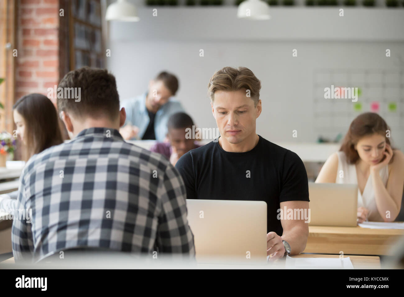 Serious businessman focused on laptop, man using pc sitting at shared ...