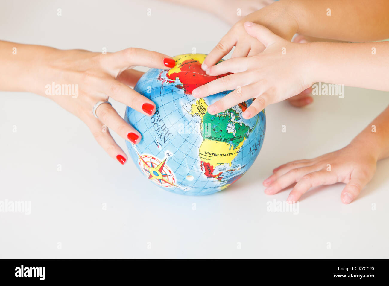 Multicultural childrens hands on a globe Stock Photo - Alamy