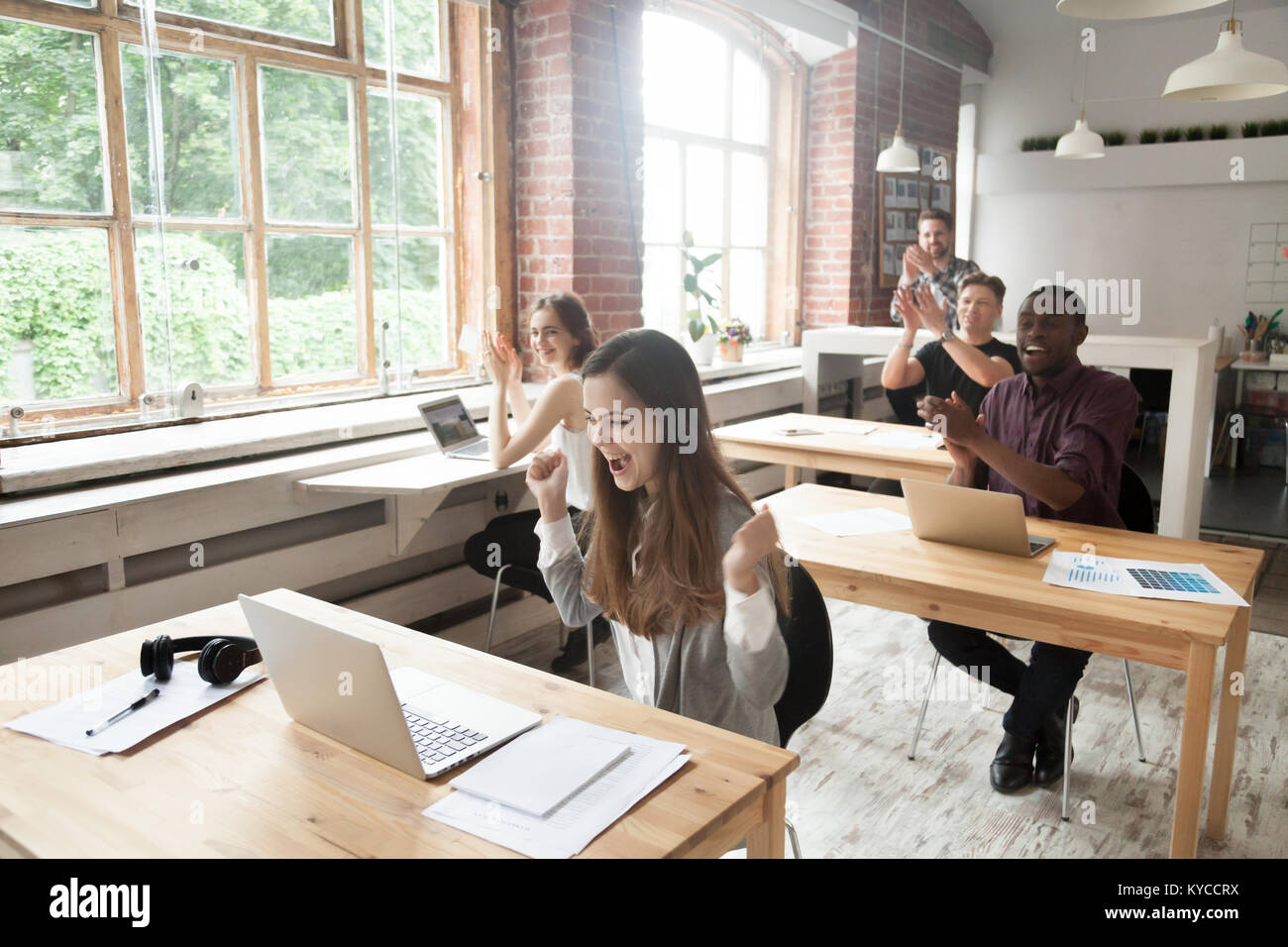 Excited surprised woman looking at laptop sharing good news with ...