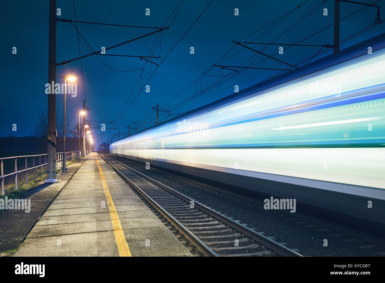 Light trail of the express train in the railway station at the night ...