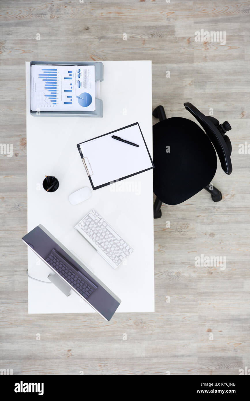 Directly above view of modern workplace: swivel chair and wooden desk ...