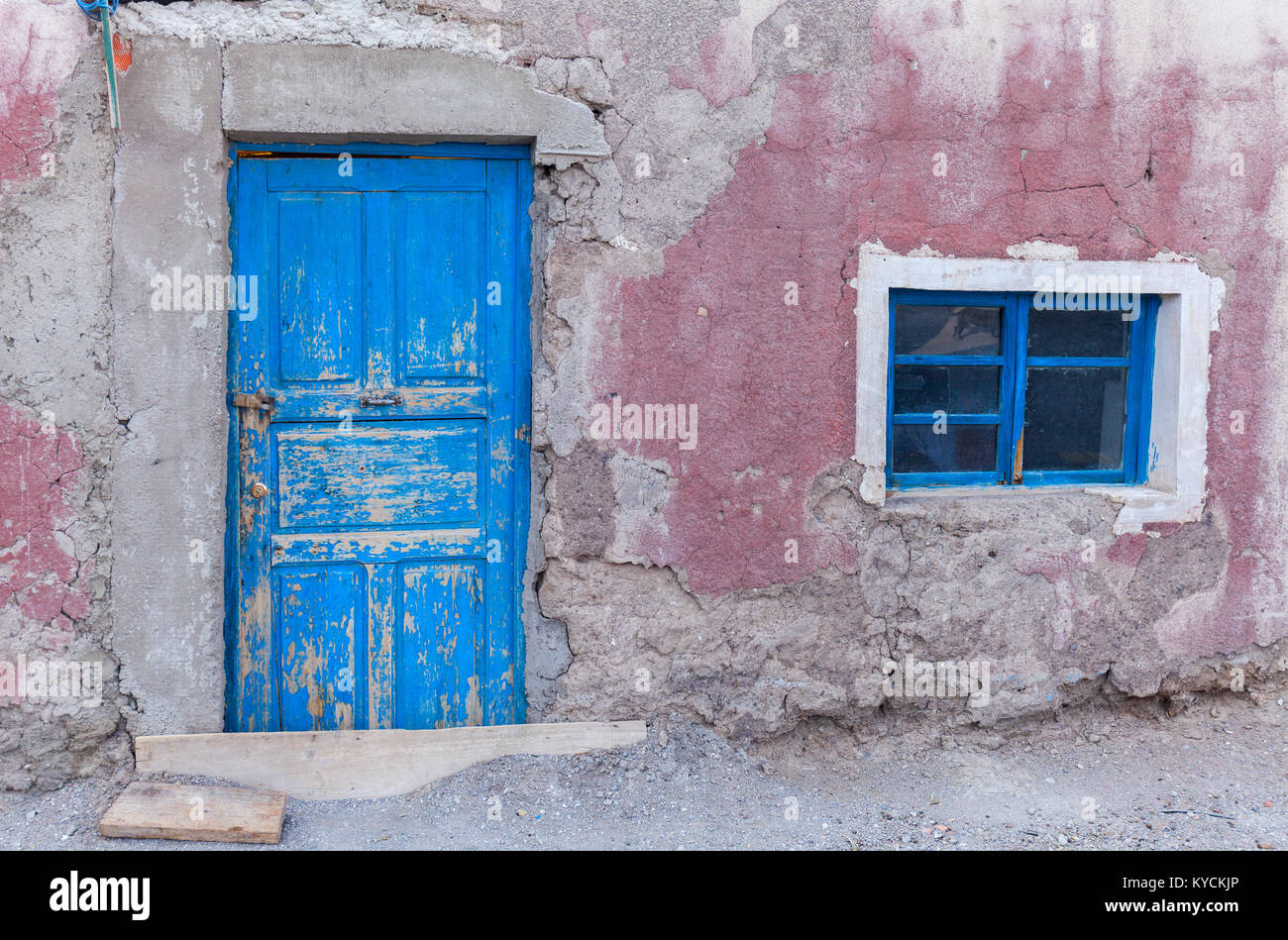 pink wall and blue old door in a poor house Stock Photo - Alamy