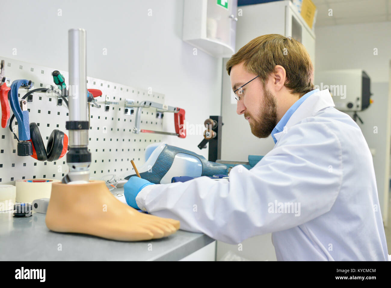 Side view portrait of young prosthetics technician making prosthetic ...