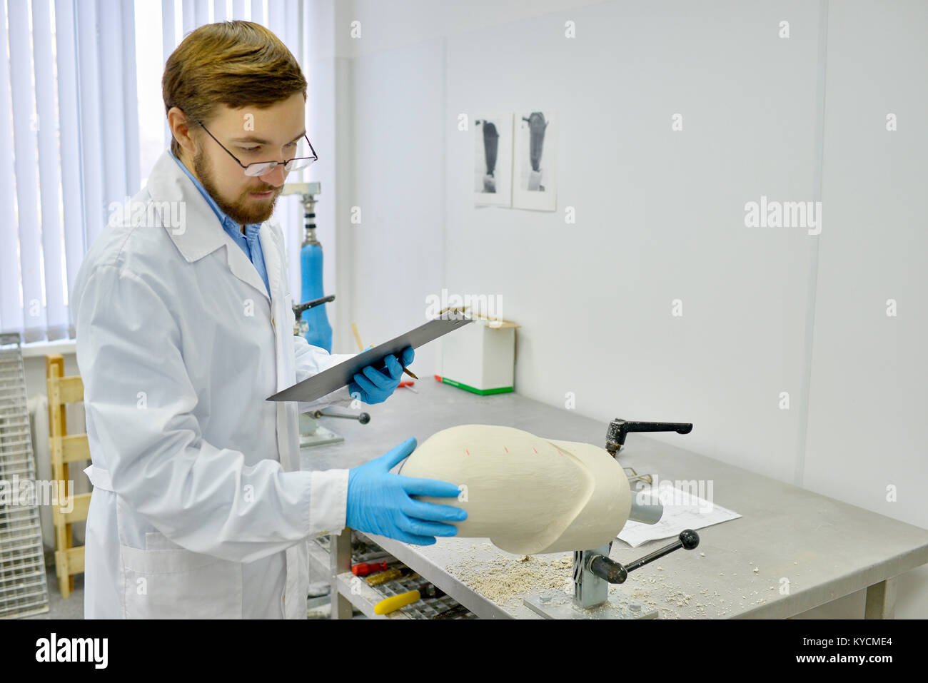 Portrait of young prosthetics technician checking prosthesis molds and ...