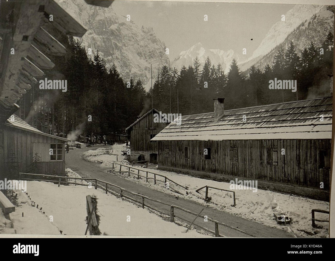 This image shows a row of barracks with a background of smoke rising ...