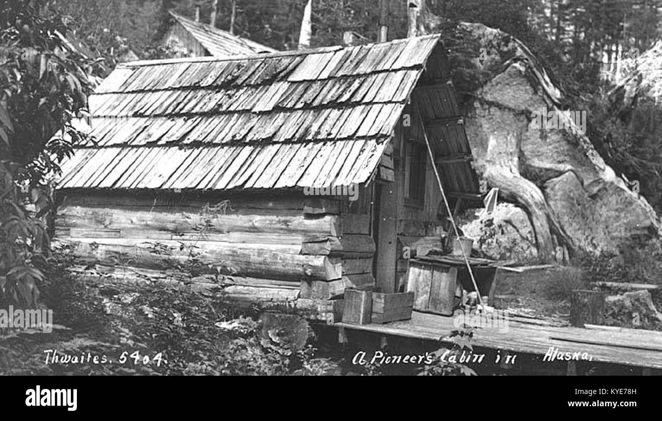 A 1912 photograph showing a trapper’s cabin in rural North America, documenting early 20th ...